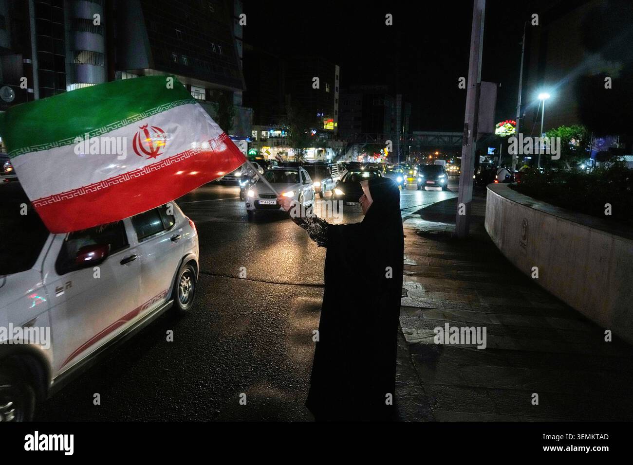 A demonstrator waves an Iranian flag in a pro-government gathering in ...