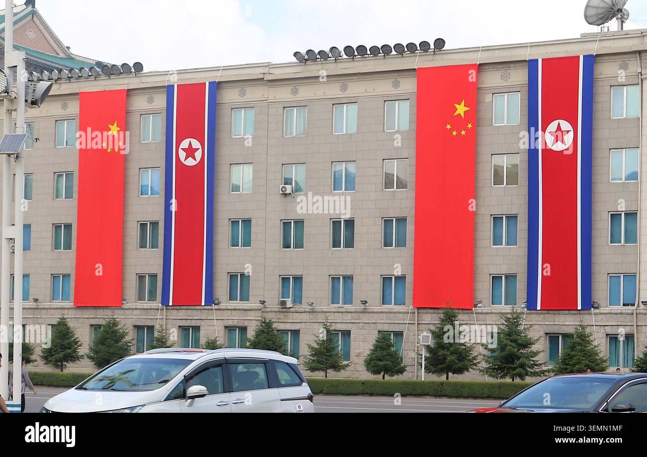 A building is decorated with the flags of China and North Korea in ...