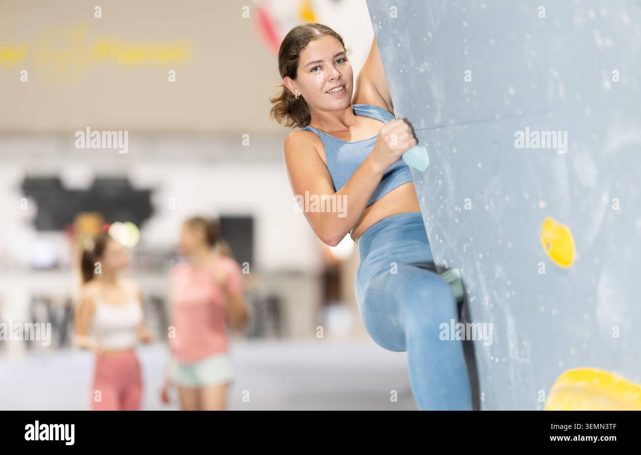 Girl in sportswear practicing rock climbing on climbing wall Stock ...