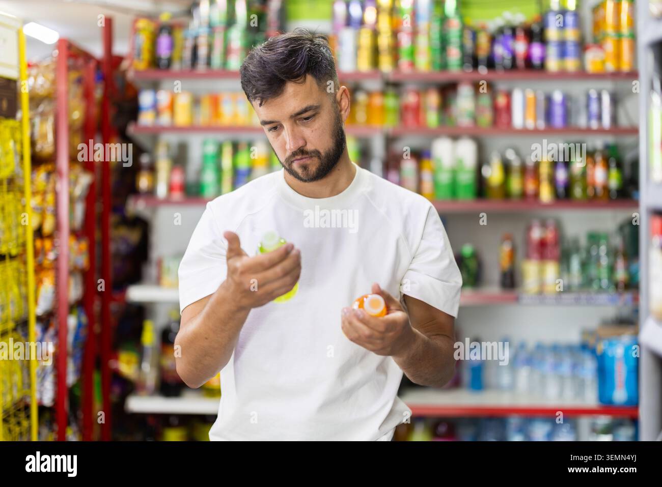Middle-aged man choosing shampoo or shower gel in supermarket Stock ...