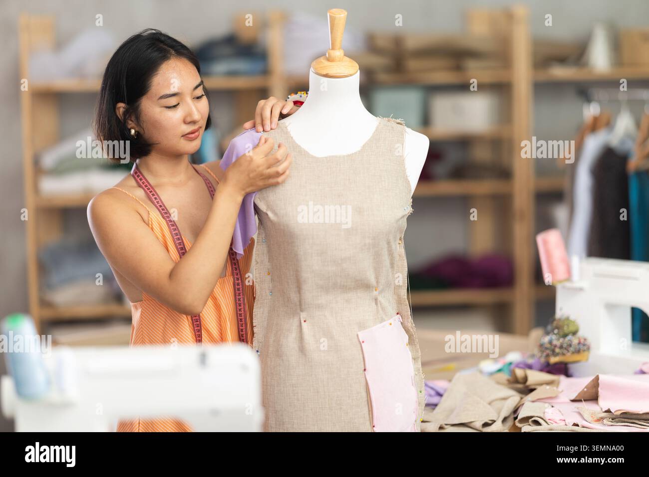 Female tailor sews new dress on a mannequin in sewing studio Stock ...