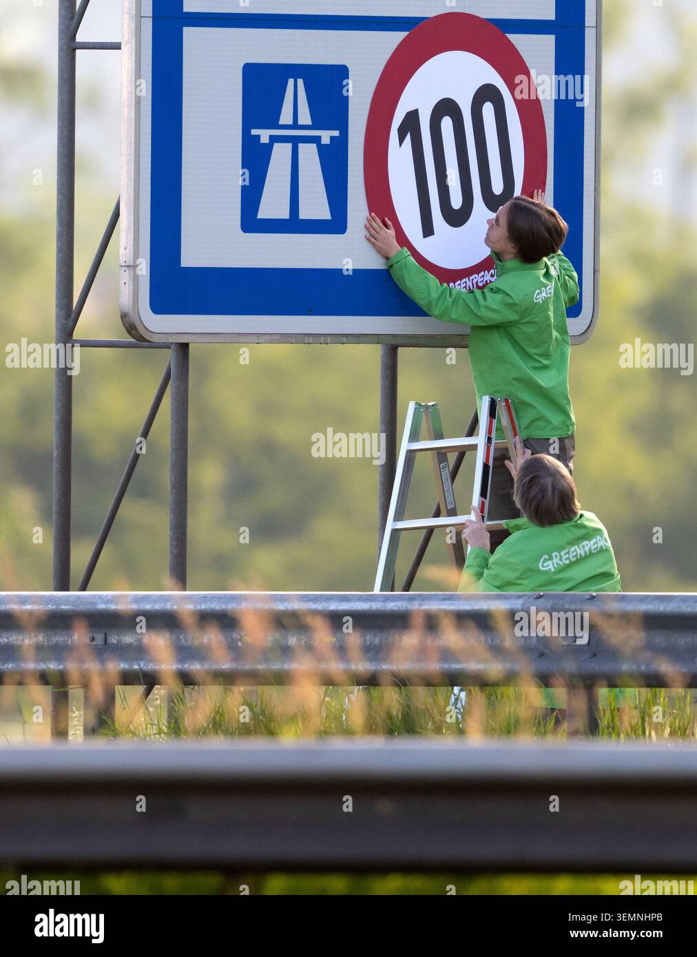 08 June 2026, Bavaria, Kiefersfelden: Greenpeace activists cover a sign ...