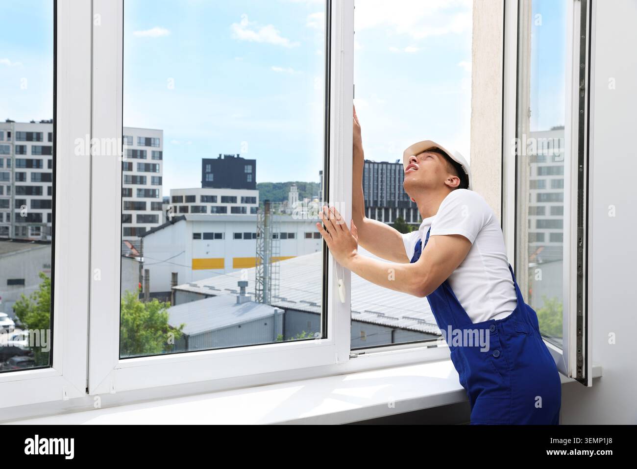 Professional worker examining window after installation indoors Stock ...
