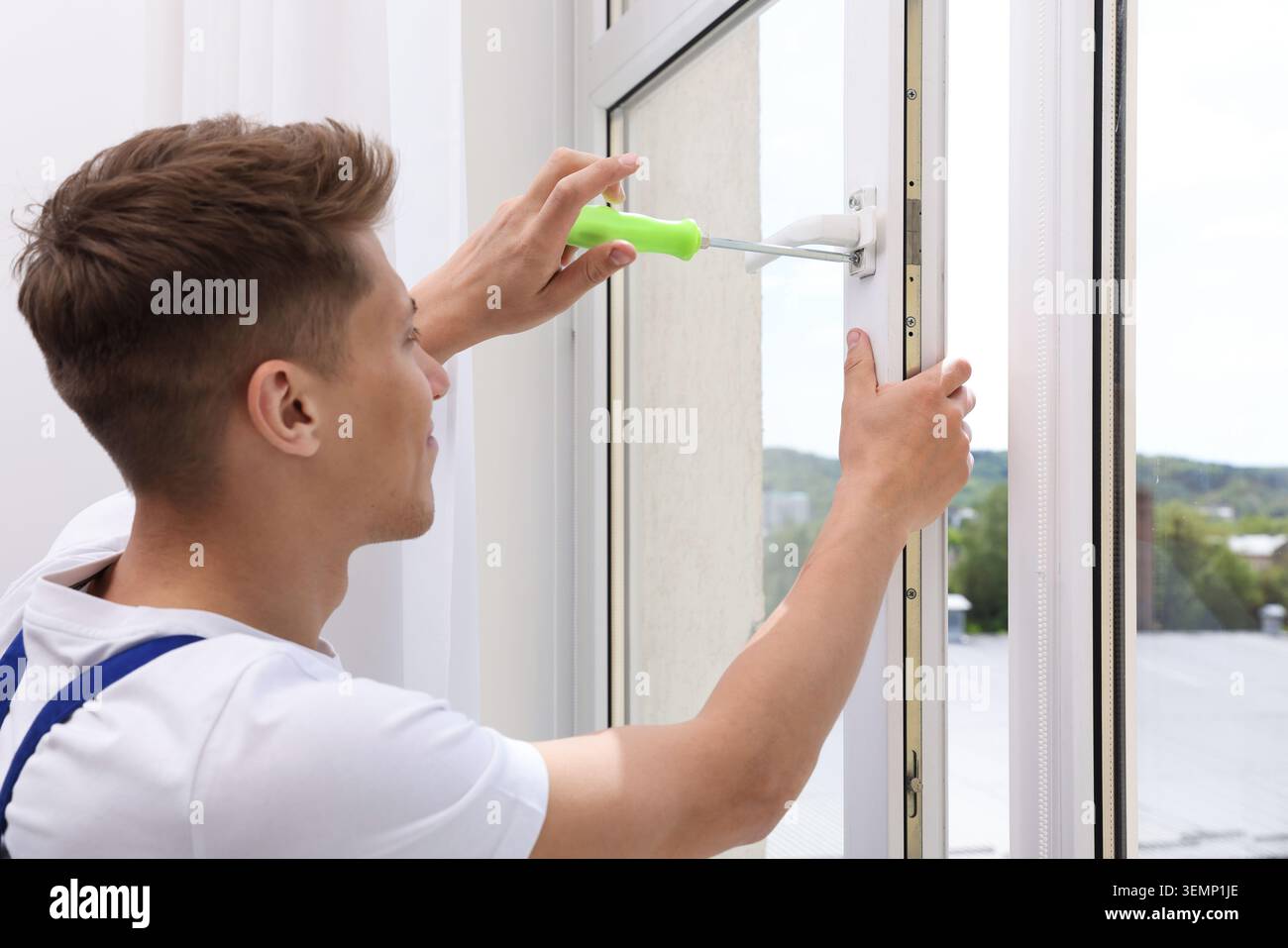 Worker with screwdriver installing window handle indoors Stock Photo ...