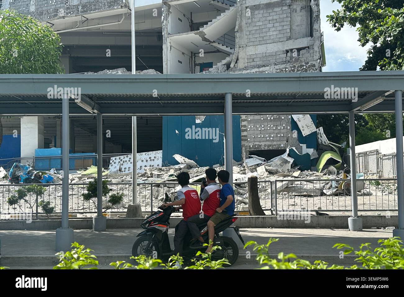 People look at a collapsed structure, following an earthquake in ...