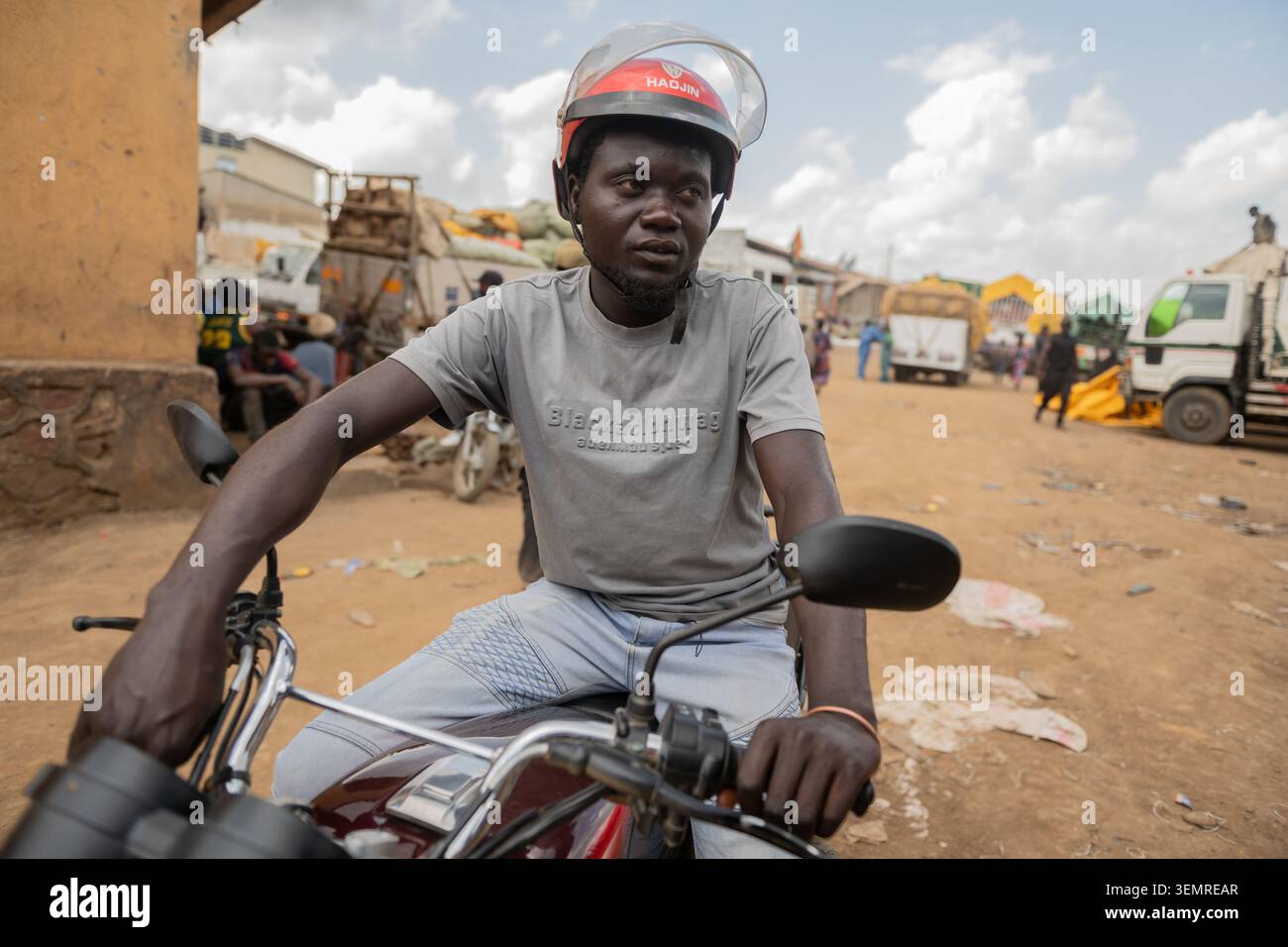 Justin Abekani, a motorcycle taxi rider, waits for passengers in Bunia ...