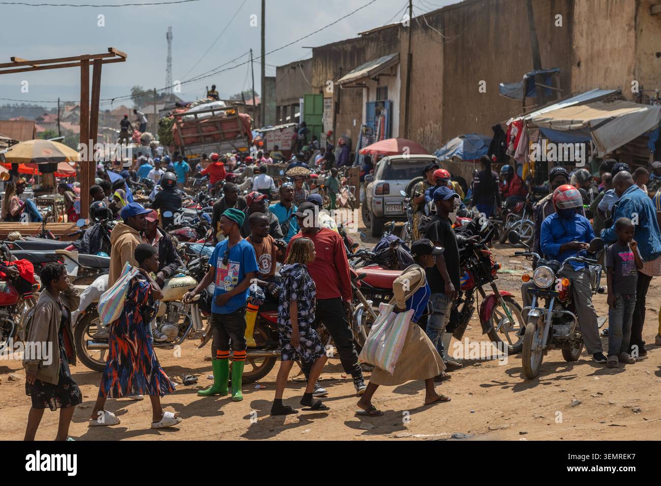 Motorcycles, trucks and pedestrians move through a busy street in Bunia ...