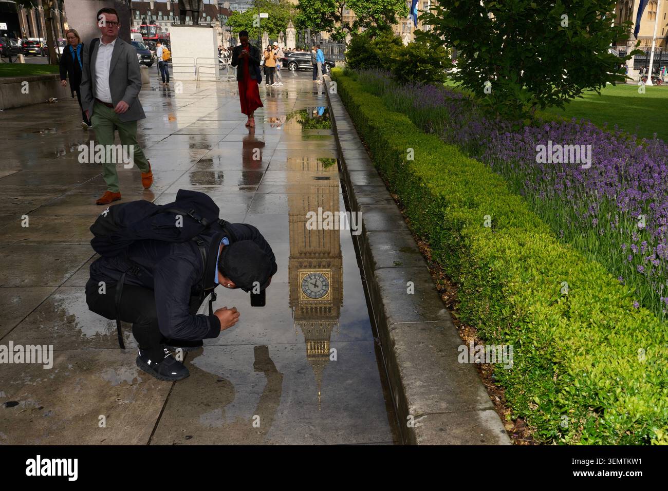 A man takes a photograph outside the Houses of Parliament in London ...