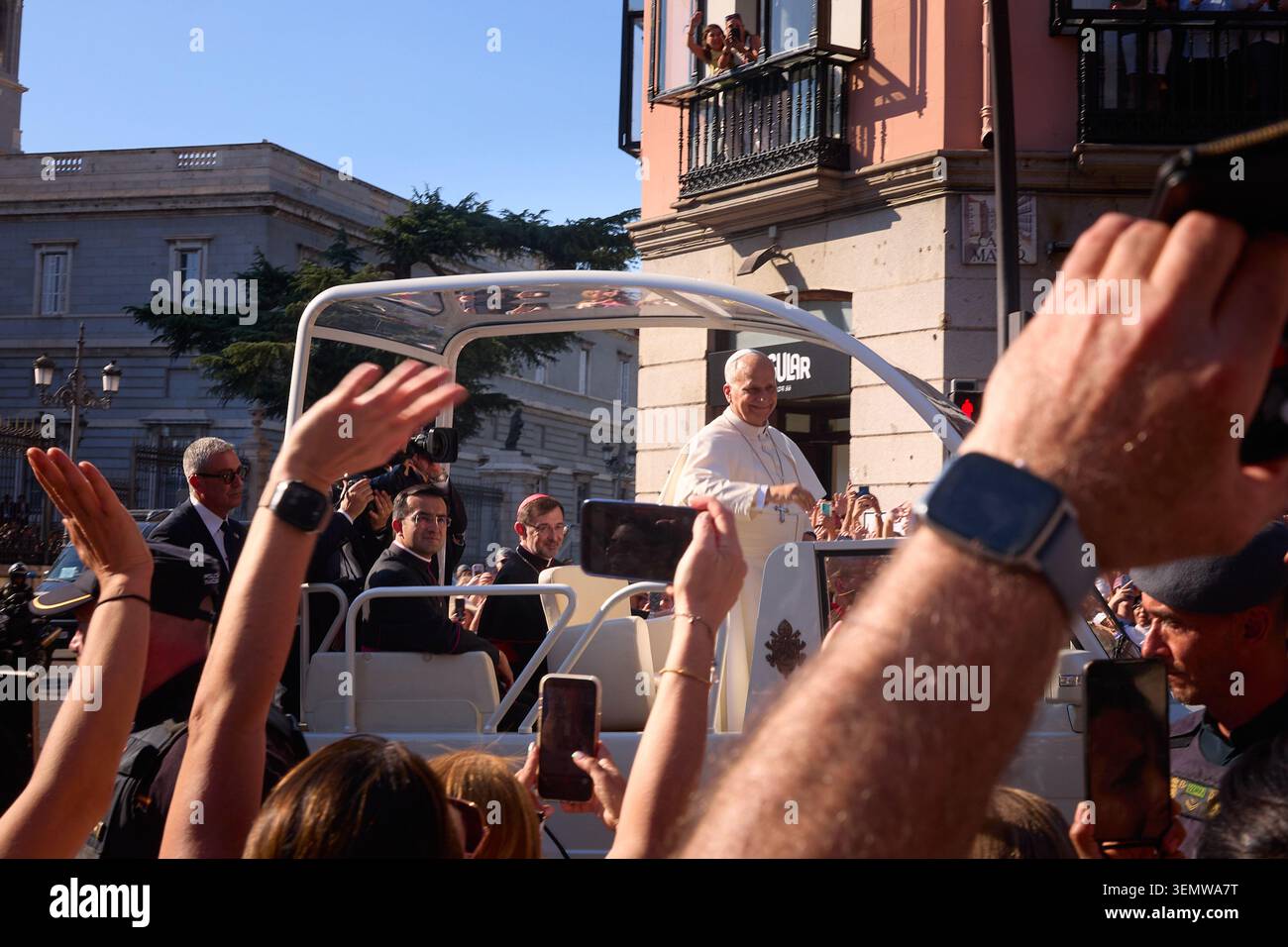 Pope Leo XIV waves to supporters as his motorcade passes through Madrid ...