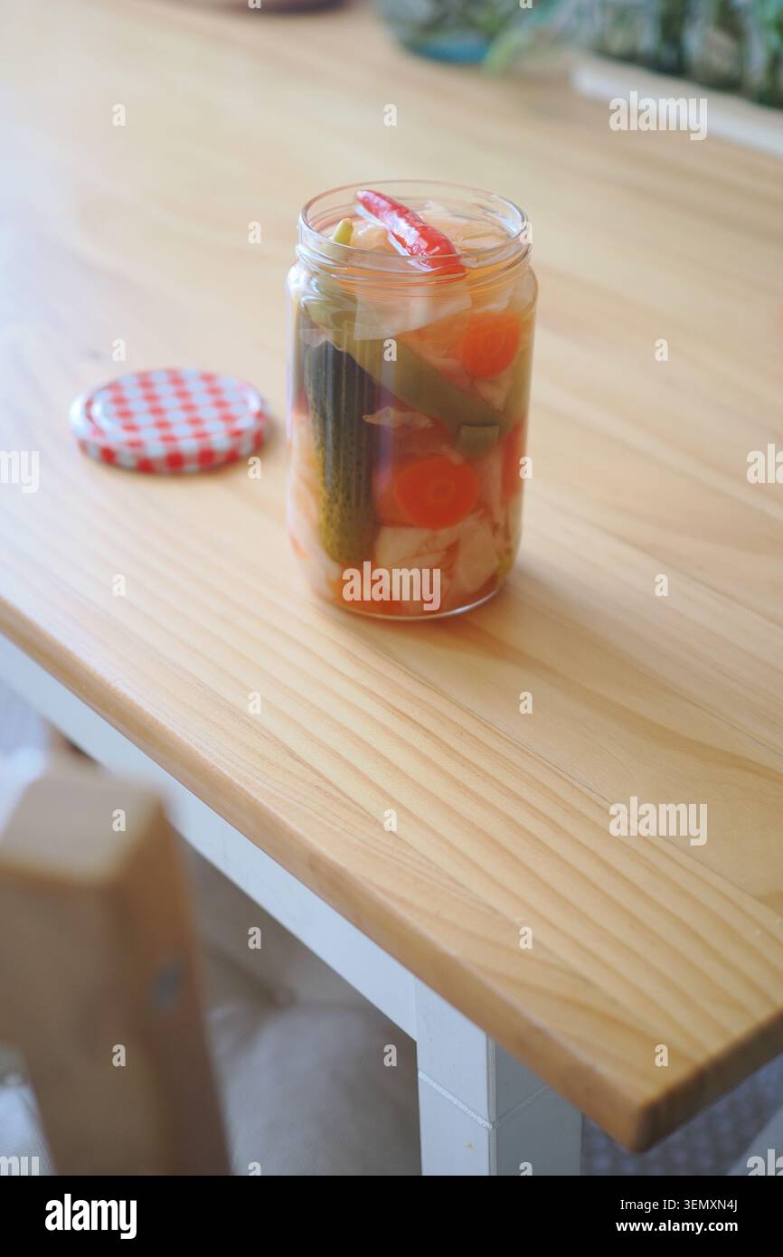 Pickled vegetables in a jar on a wooden table Stock Photo - Alamy