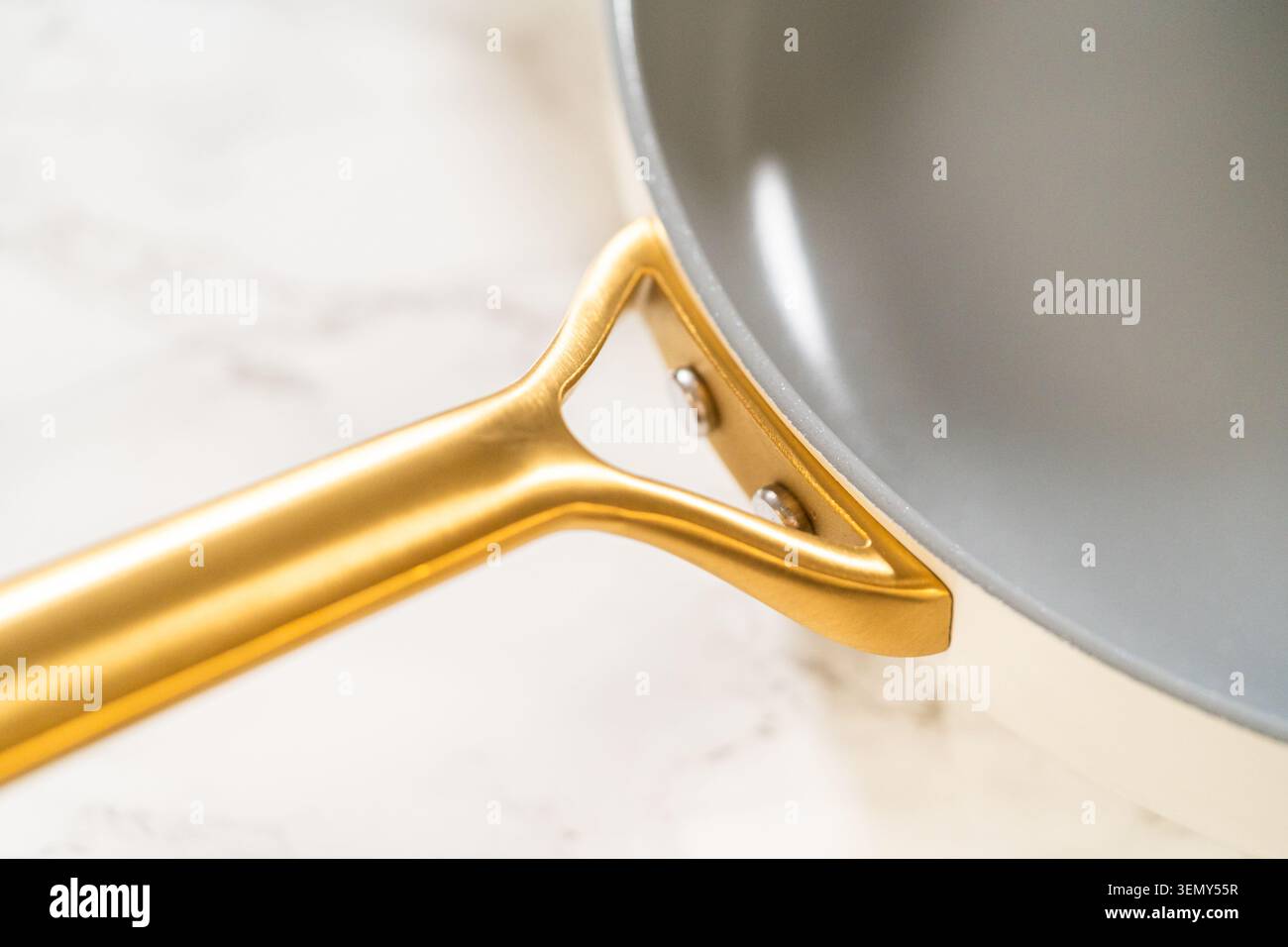 High-resolution closeup of a nonstick skillet with a gold handle on a ...