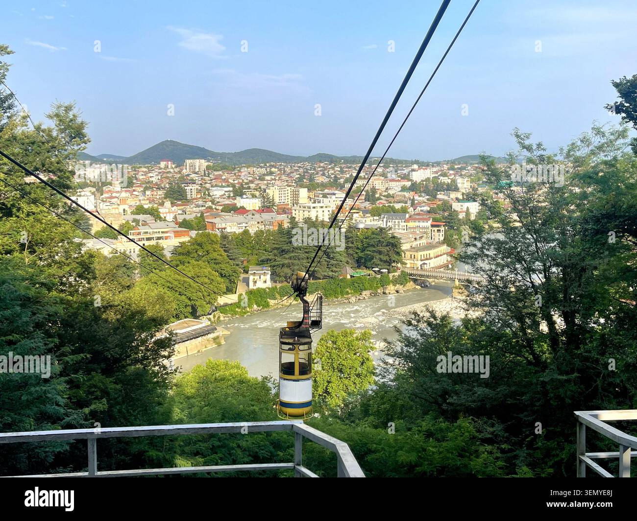 Yellow cable cars, cableway over the bridge, Rioni river and city blue ...