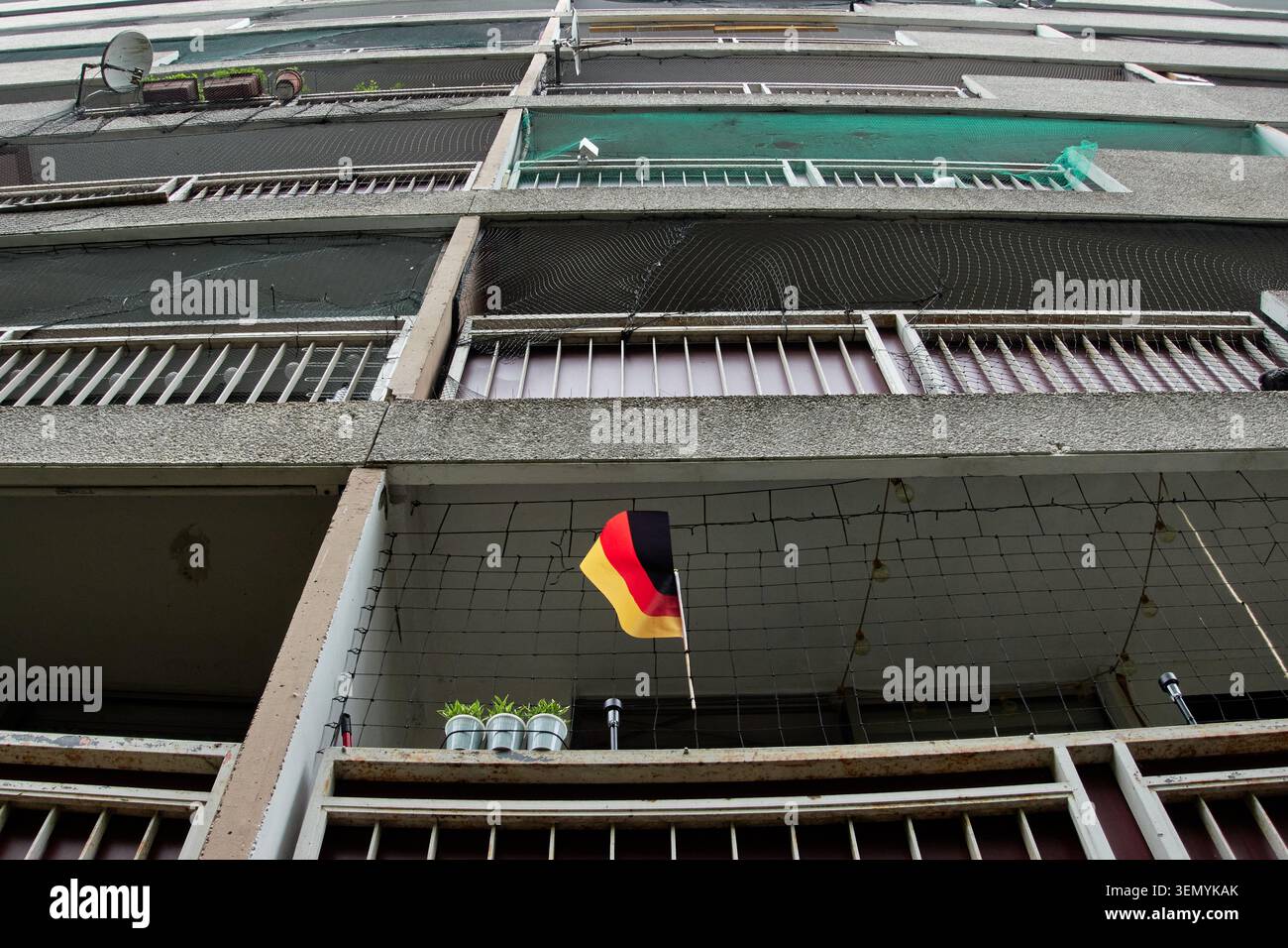 The balcony of an apartment building is decorated with a German flag in ...