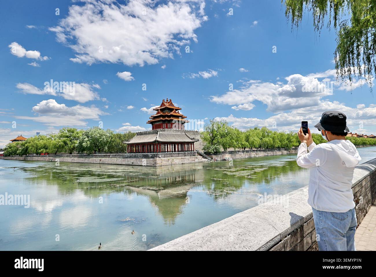 Tourists take photos of the Forbidden City's corner tower against clear ...
