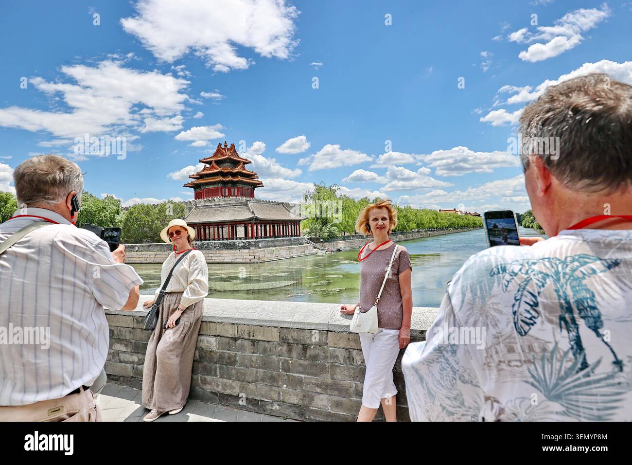 Tourists take photos of the Forbidden City's corner tower against clear ...