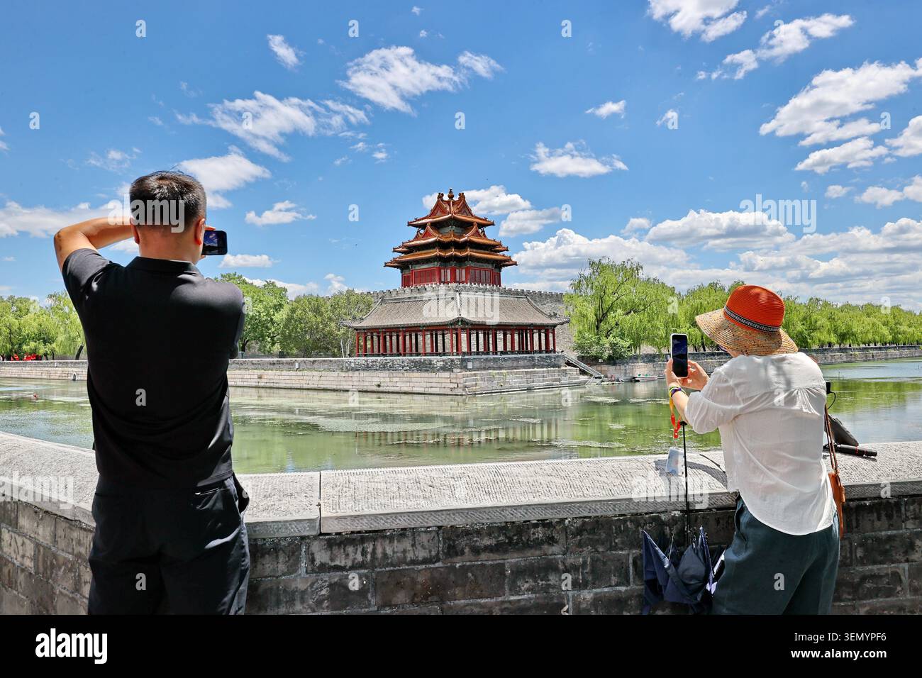 Tourists take photos of the Forbidden City's corner tower against clear ...