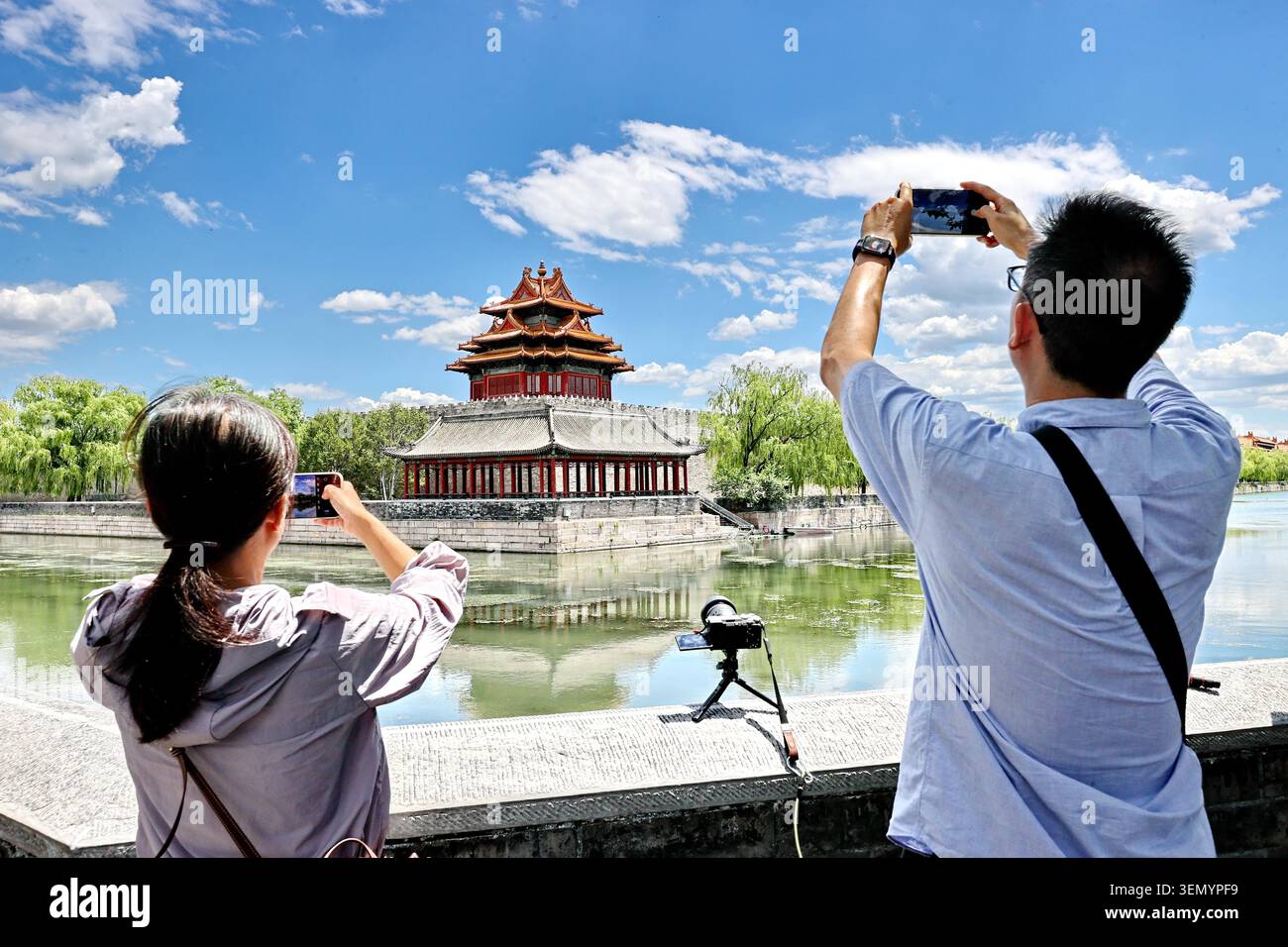 Tourists take photos of the Forbidden City's corner tower against clear ...