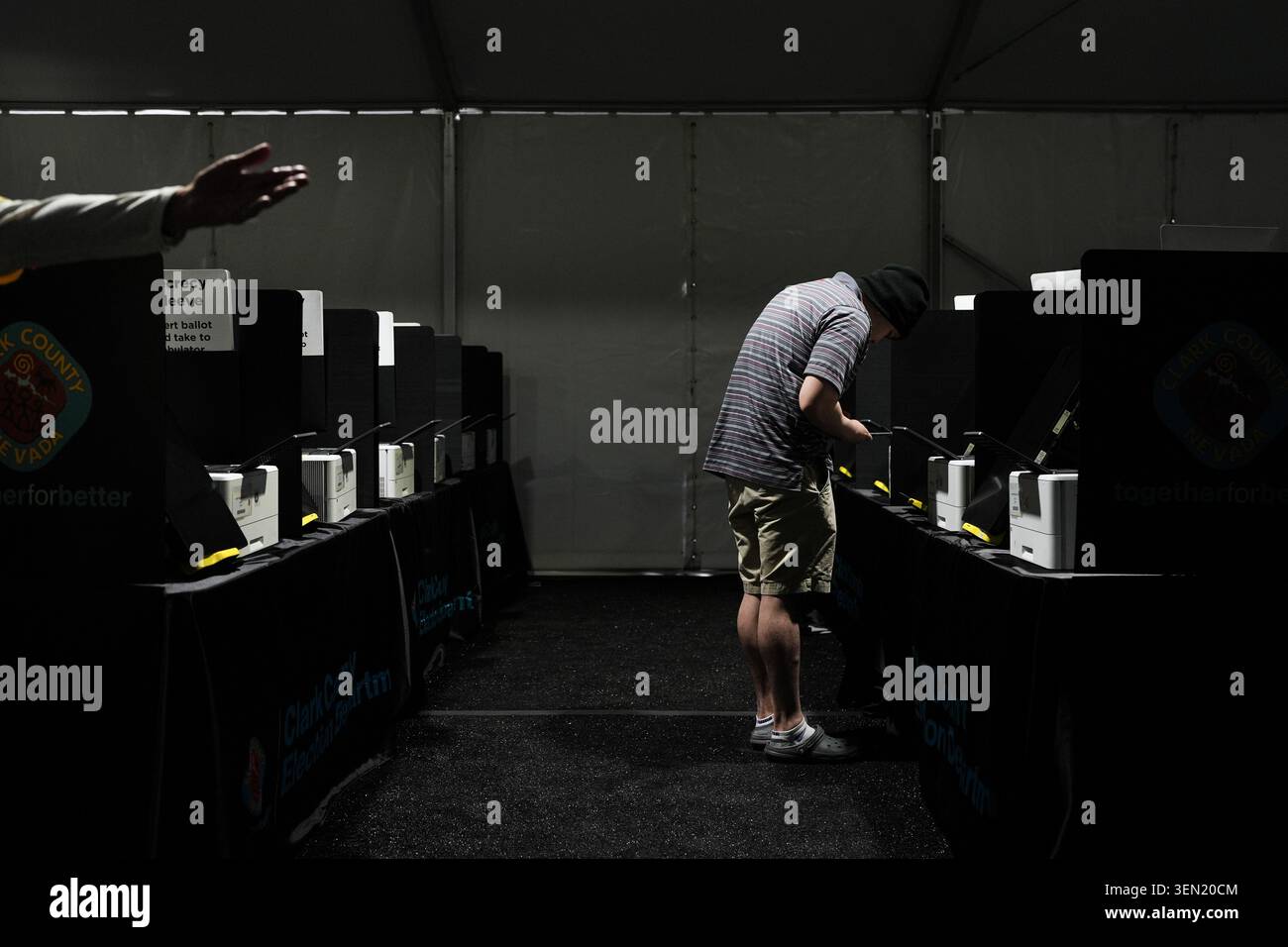 A voter looks at his phone while casting a ballot at a vote center set ...