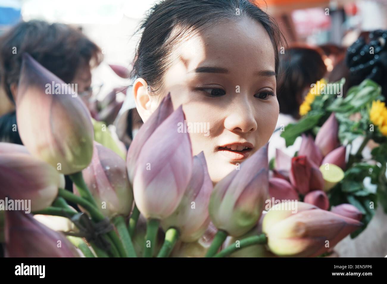 Visitors buy fresh lotus flowers at a morning market in Hangzhou, east ...