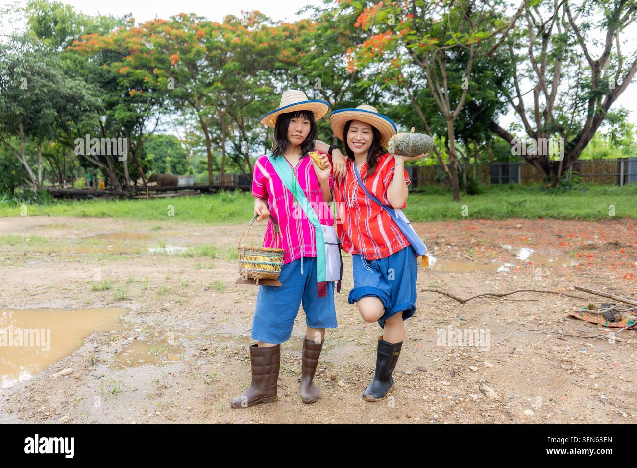 Asian woman farmer hat basket vegetable muddy field smiling pair ...