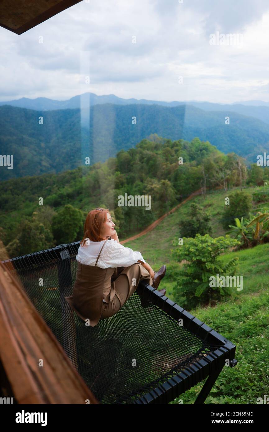 Contemplative woman enjoys peaceful relaxation on net balcony ...