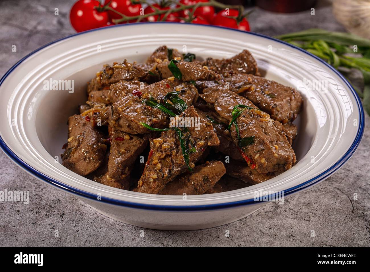 Savory cooked beef liver slices seasoned with herbs spices, served in a ...
