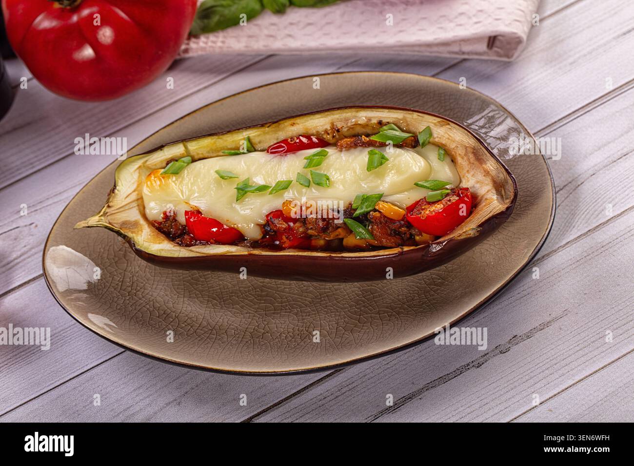 Baked eggplant boat filled with savory mixture, melted cheese, red ...