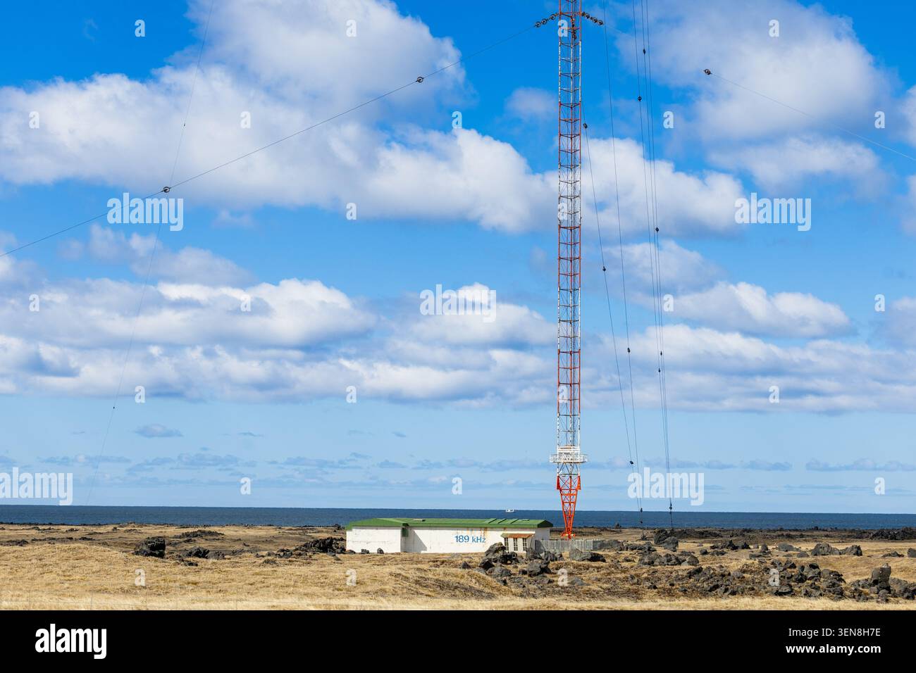 A tall radio transmission mast rises above the barren volcanic ...