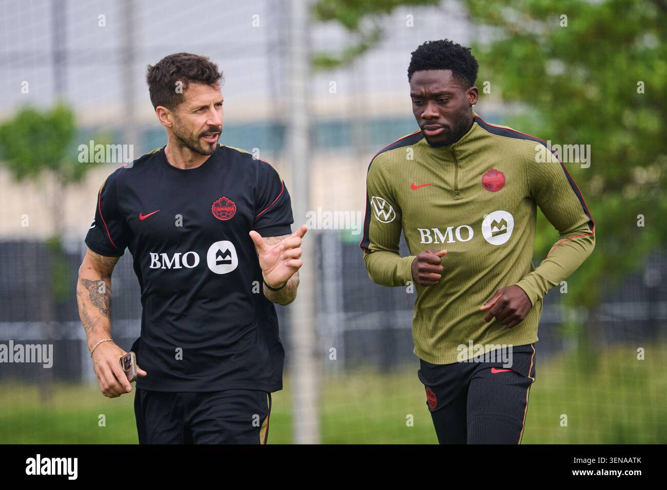 Canada's Alphonso Davies, right, runs laps during a World Cup soccer ...