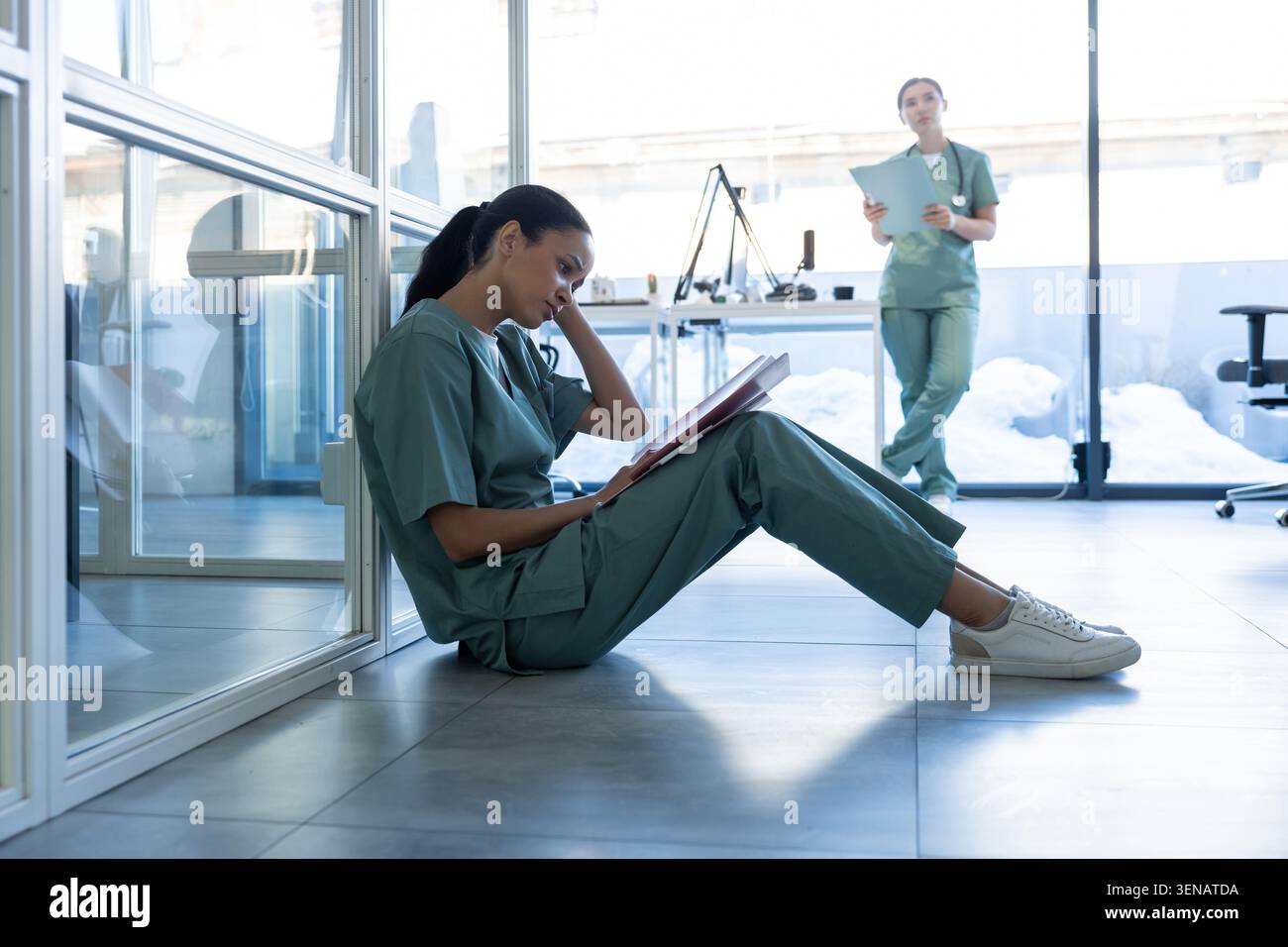 New case. Dark-haired female doctor sitting on the floor and ...