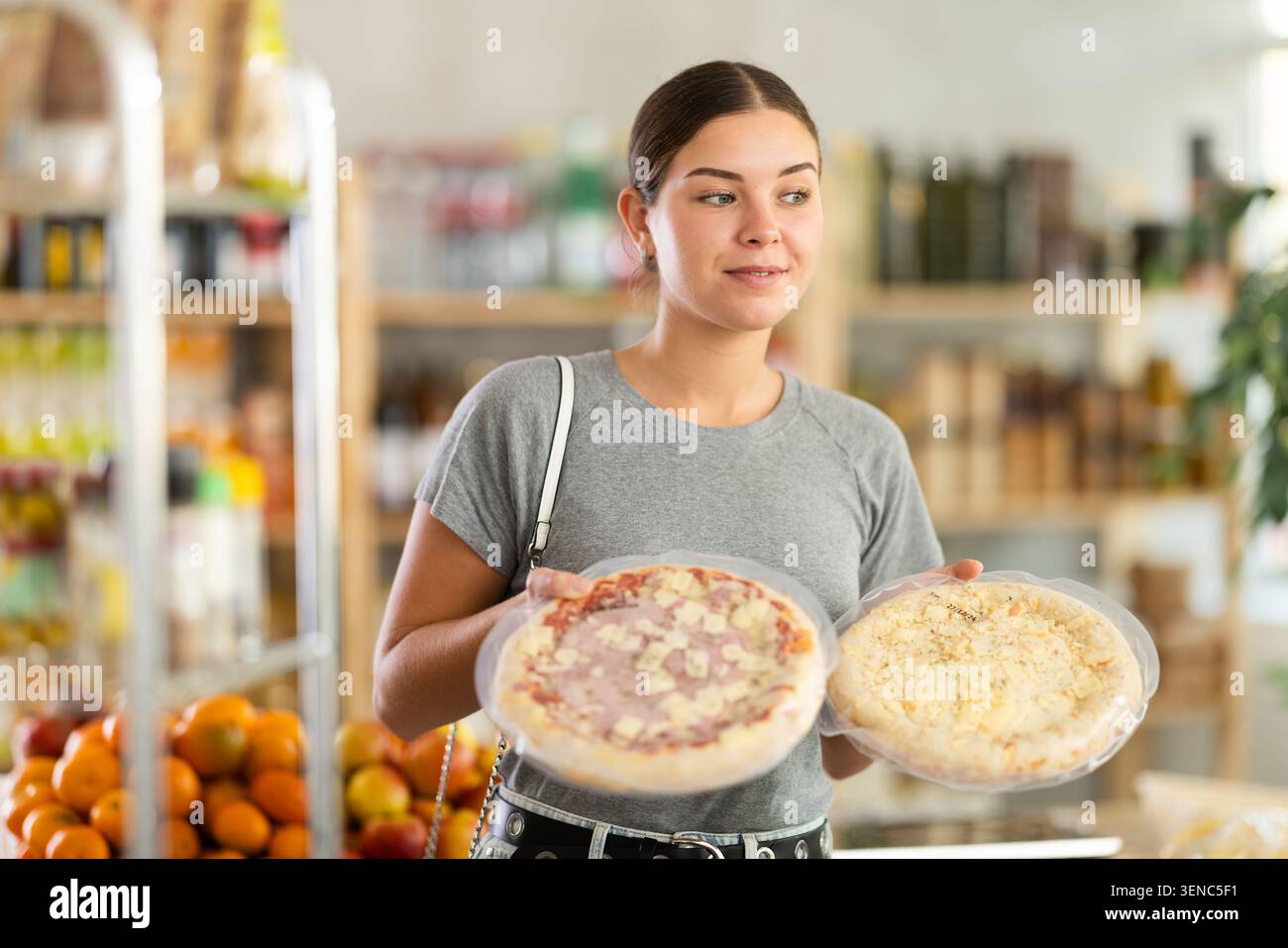 European youth girl choose and buy pizza with filling in store Stock ...
