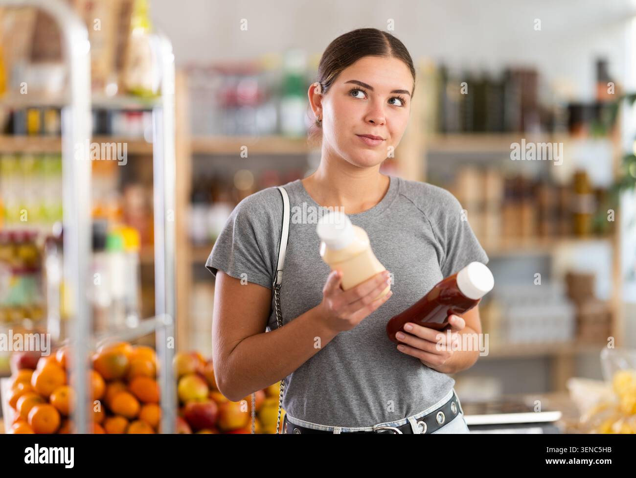Woman choosing sauce in the store Stock Photo - Alamy