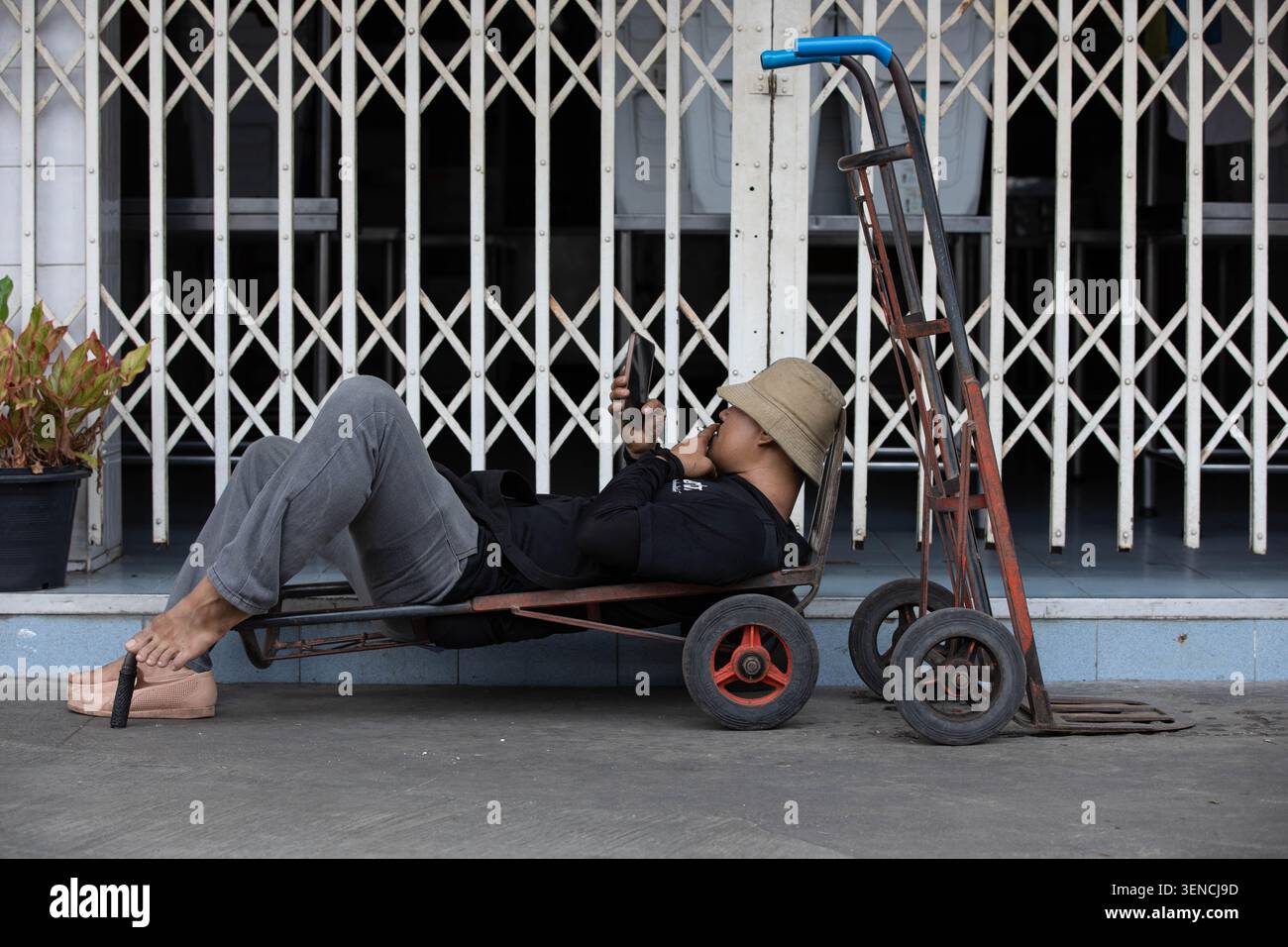 BANGKOK, THAILAND - MAY 23, 2026: Male worker using smartphone while ...