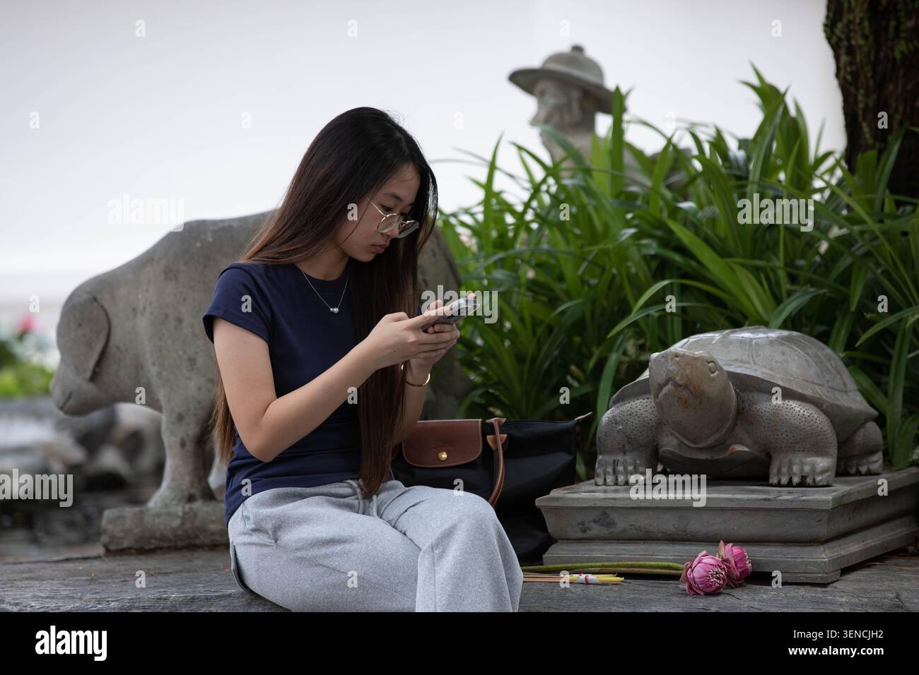 BANGKOK, THAILAND - MAY 23, 2026: Woman using smartphone while sitting ...