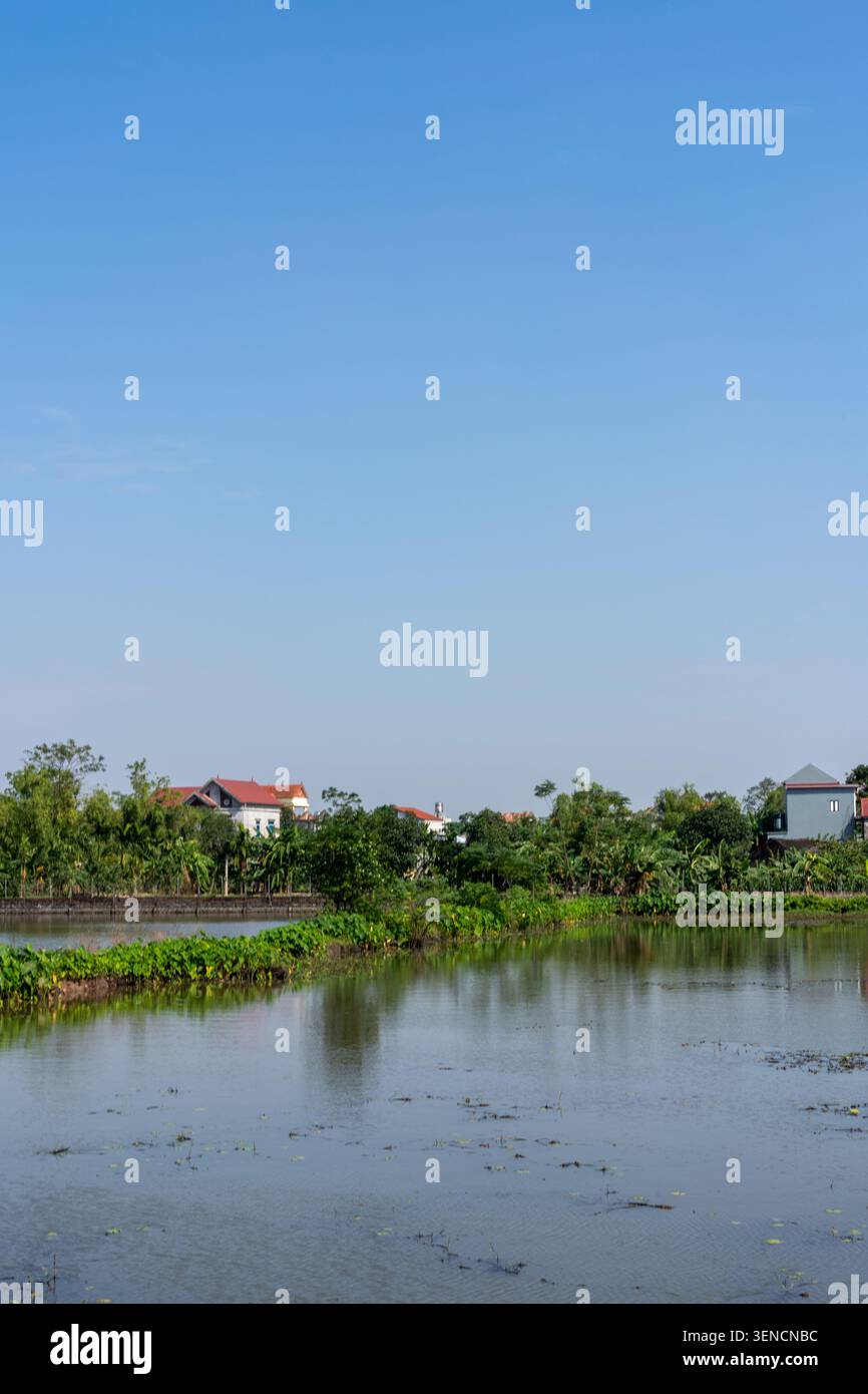 Rural village waterway with residential houses and lush vegetation in ...