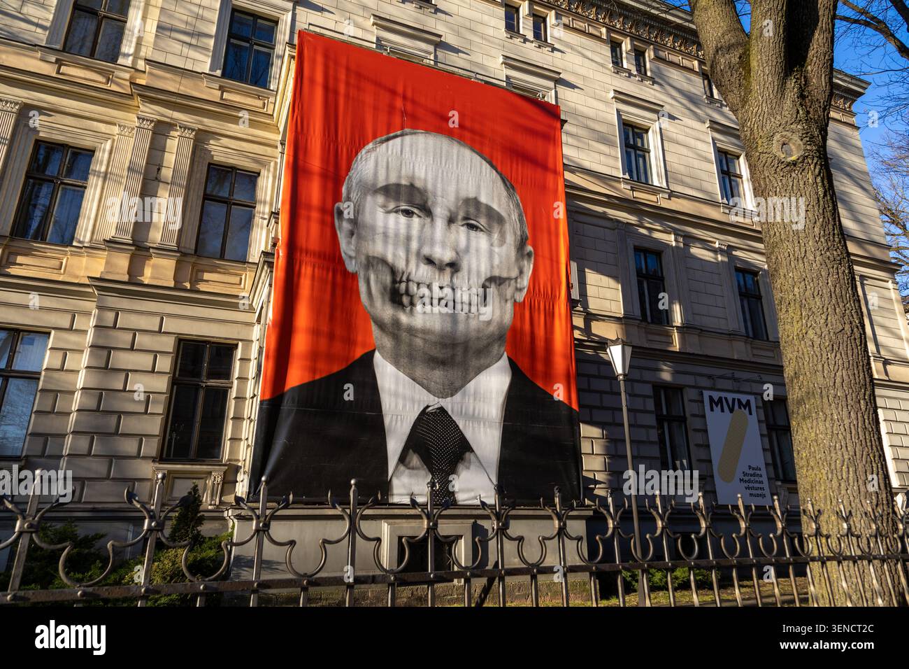 A giant protest banner depicting a skull-faced portrait of Vladimir ...