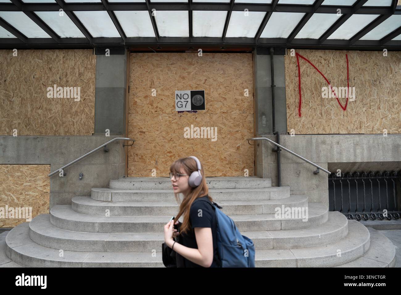 A pedestrian walks past a poster against the upcoming G7 summit on a ...