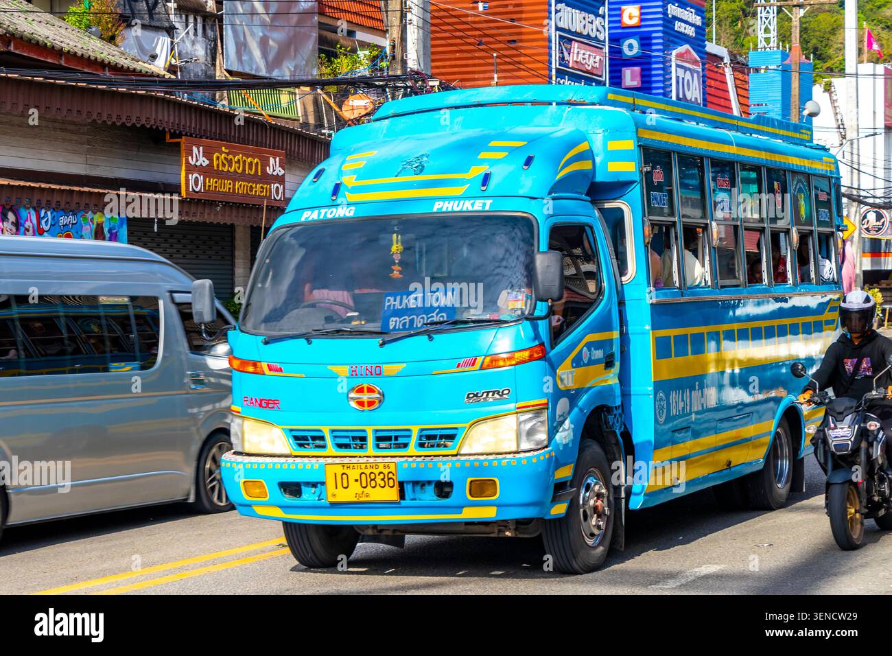 Blue Smart Bus crossing busy tropical urban intersection with traffic ...