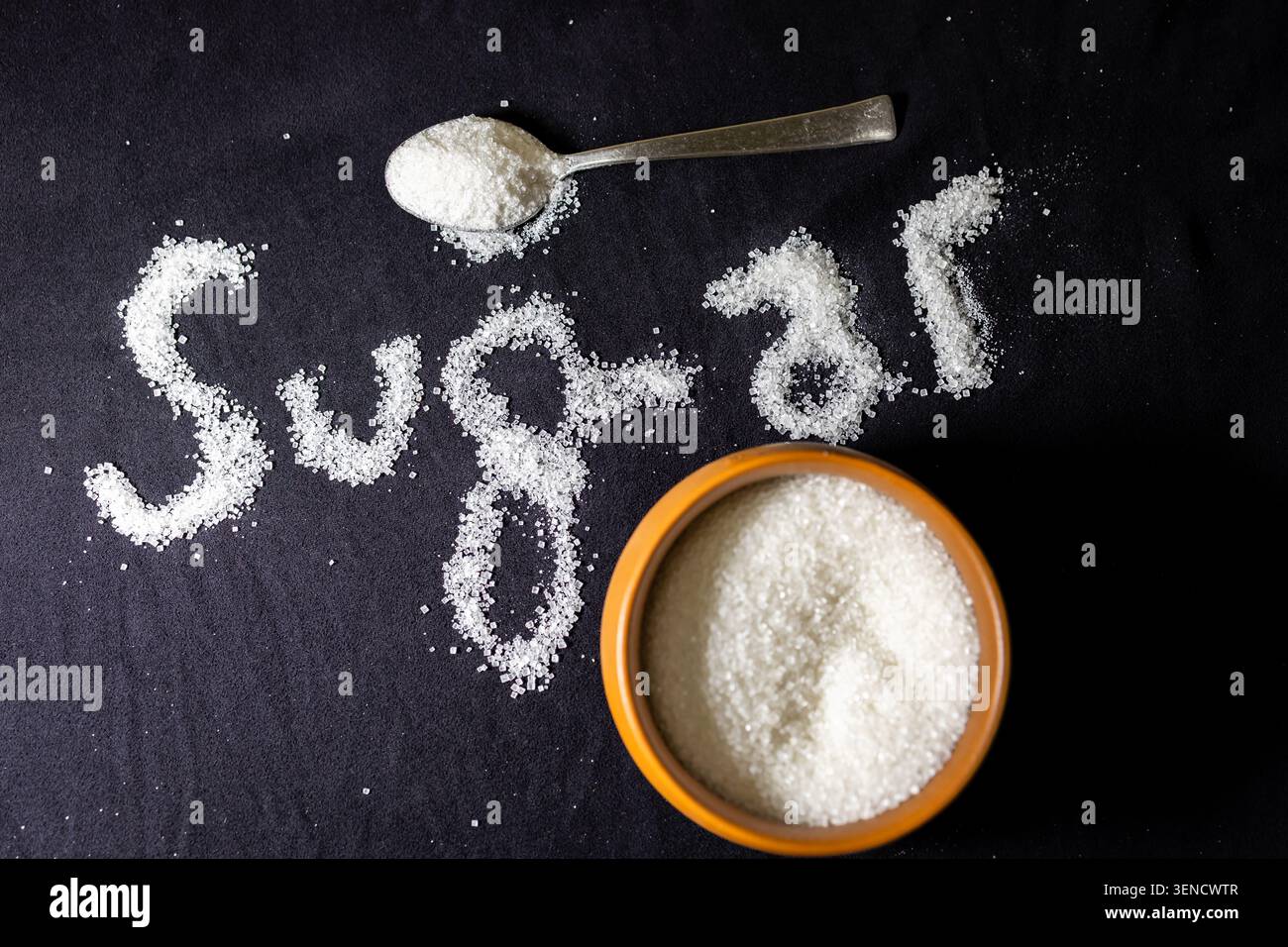 sugar text made from granulated sugar crystals with bowl and spoon on ...