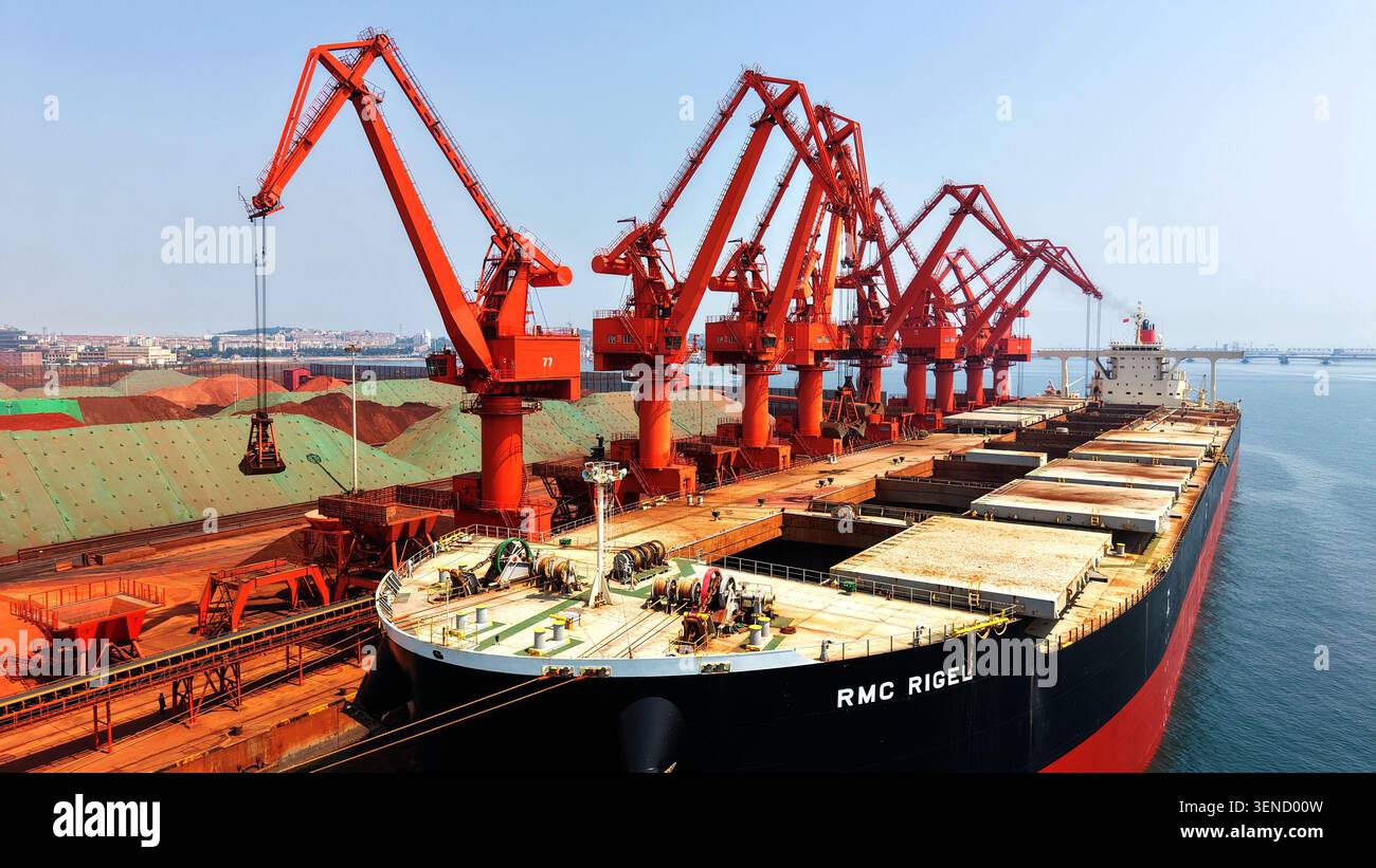 Workers spray water to suppress dust at the ore yard of Qingdao Port in ...