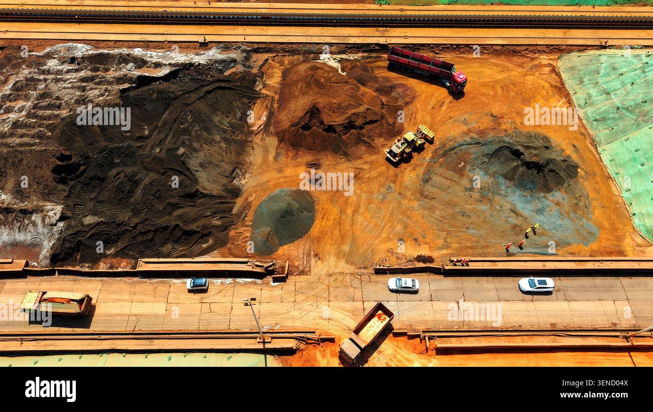 Workers spray water to suppress dust at the ore yard of Qingdao Port in ...