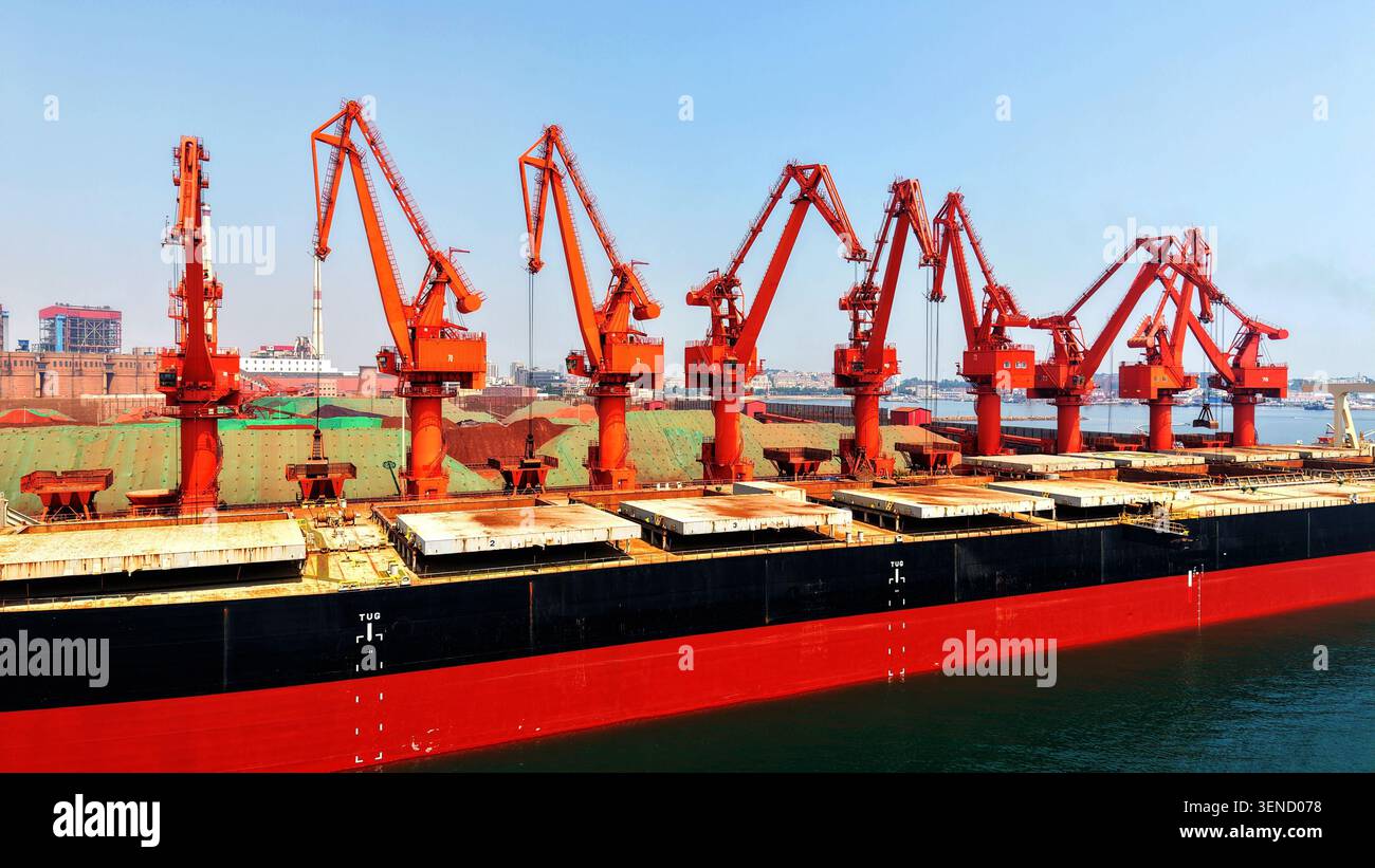 Workers spray water to suppress dust at the ore yard of Qingdao Port in ...