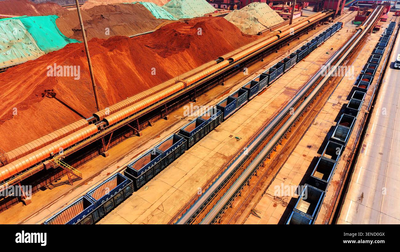 Workers spray water to suppress dust at the ore yard of Qingdao Port in ...