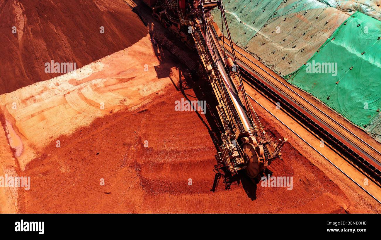Workers spray water to suppress dust at the ore yard of Qingdao Port in ...