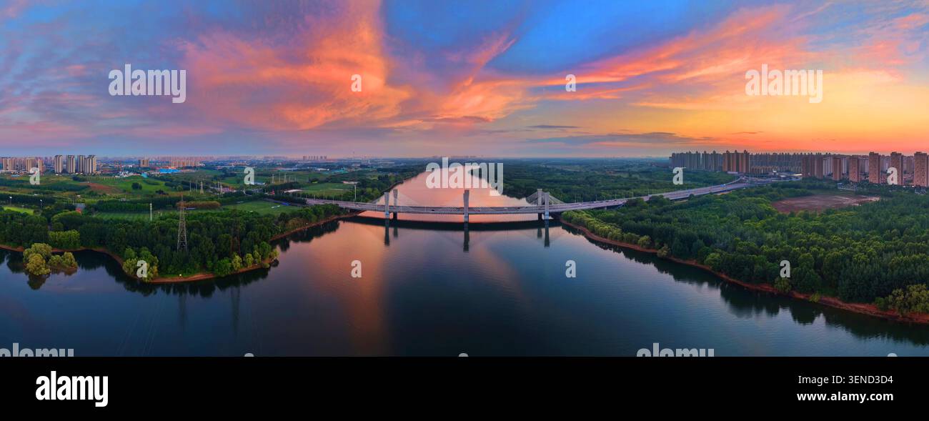 The skyline of Shenyang is bathed in sunset glow over Hunhe River in ...