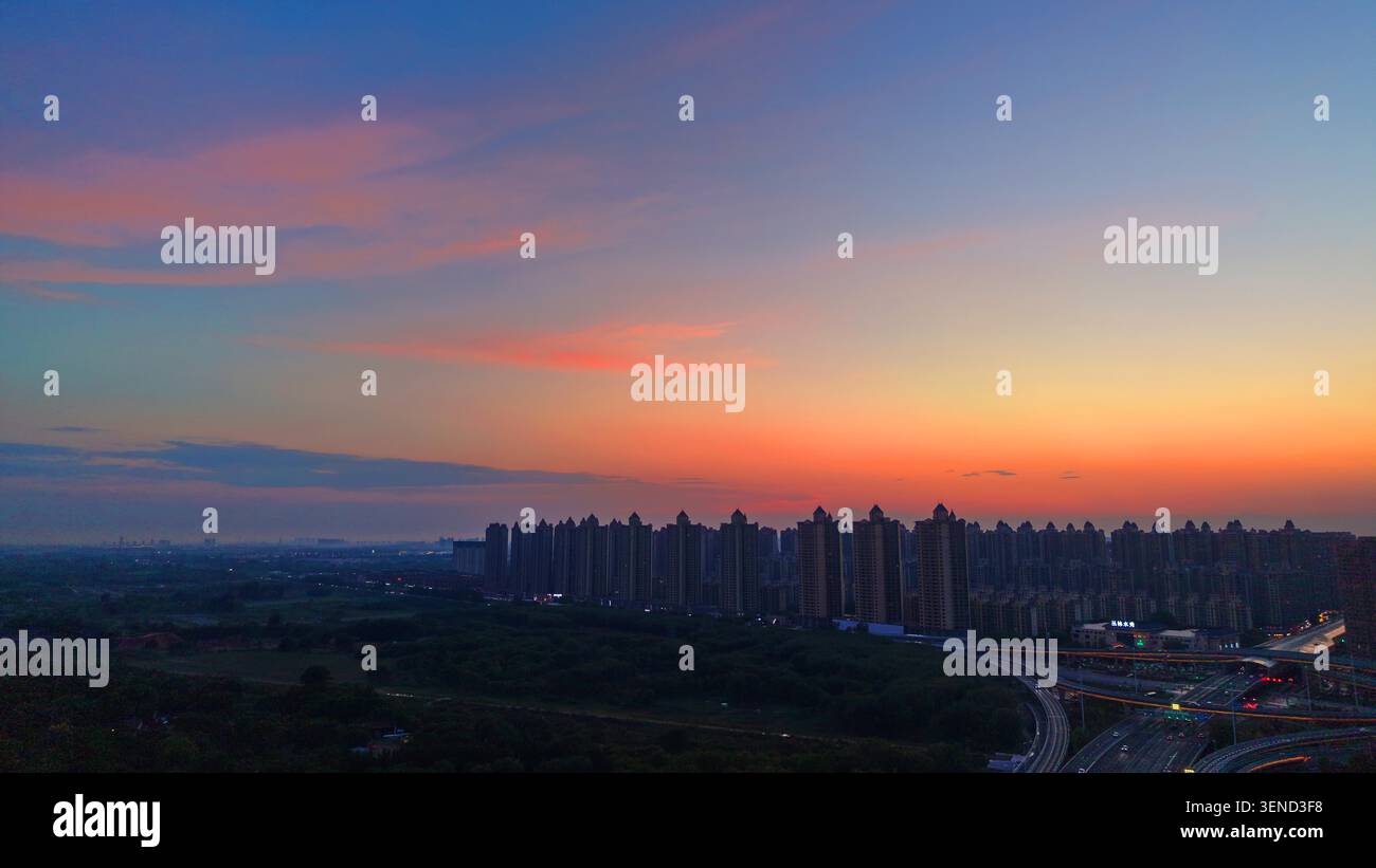 The skyline of Shenyang is bathed in sunset glow over Hunhe River in ...