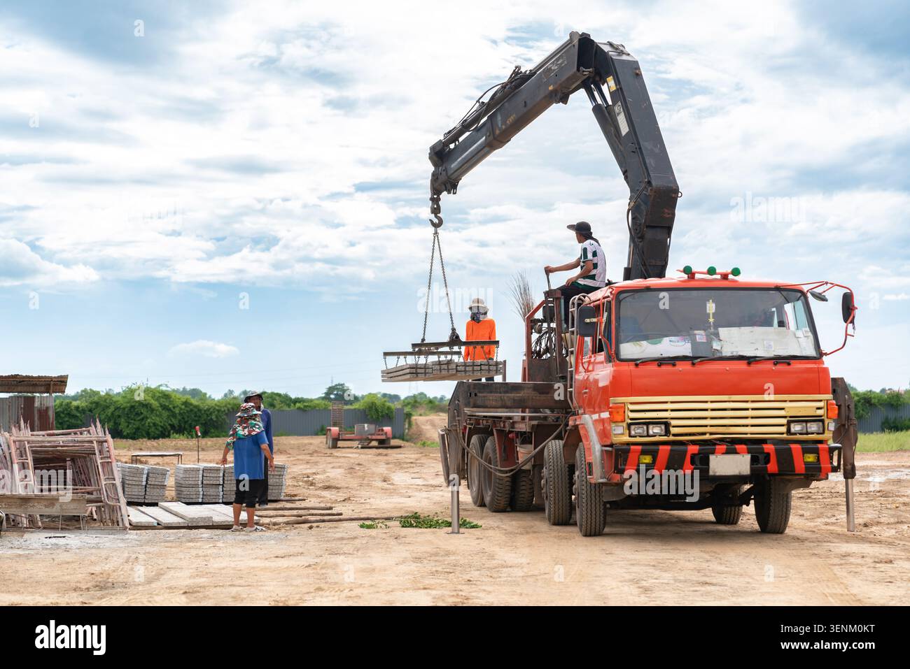 Mobile truck-mounted crane lifting heavy concrete building materials on ...