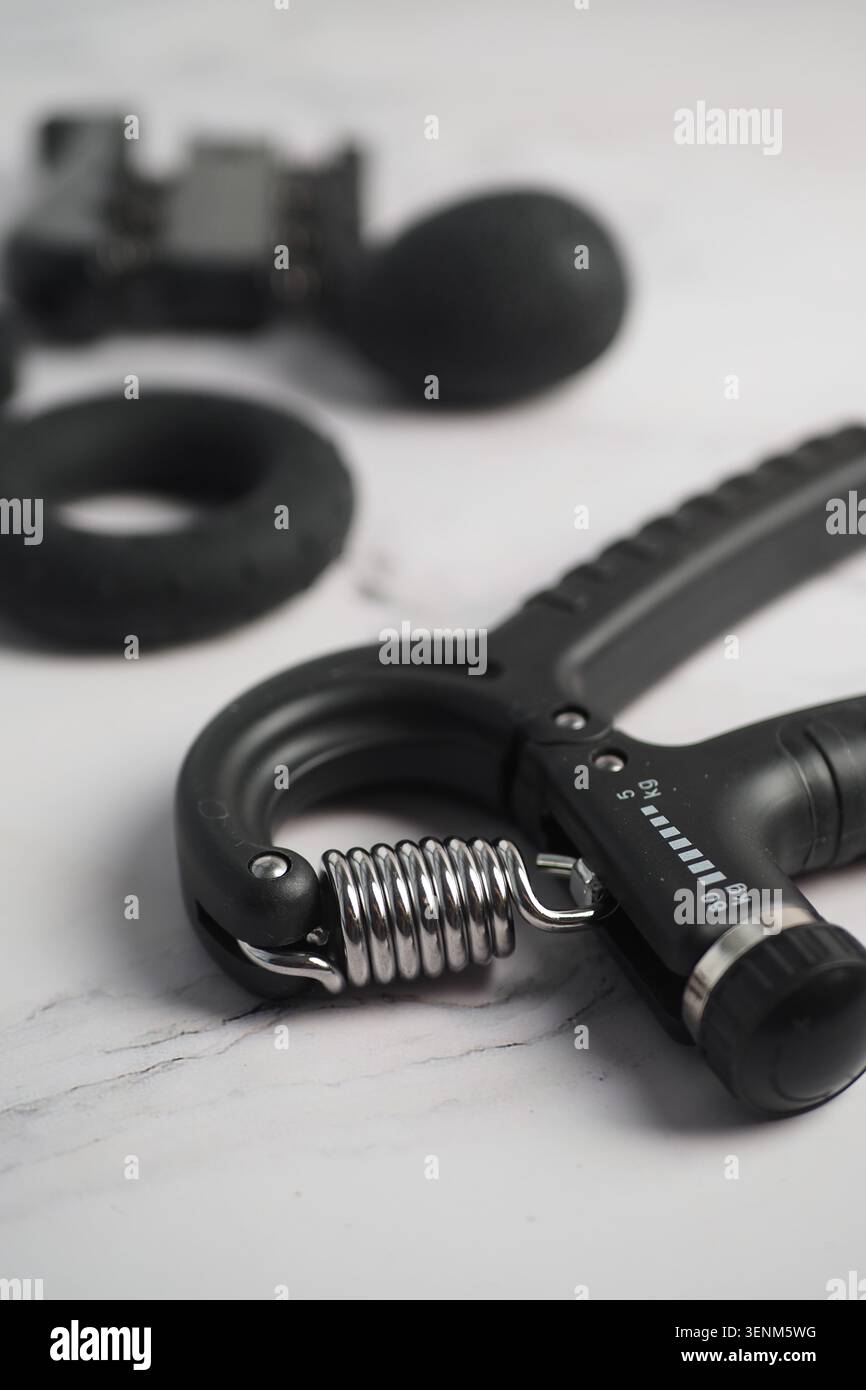 Hand grip strengthener on a flat surface with workout gear Stock Photo ...