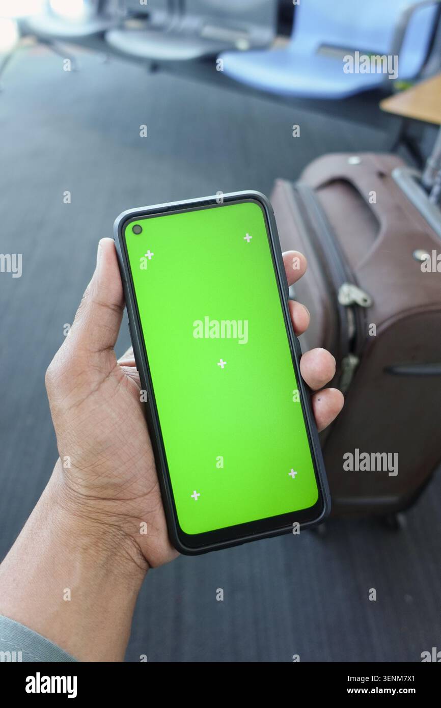 Hand holding a blank smartphone in an airport Stock Photo - Alamy