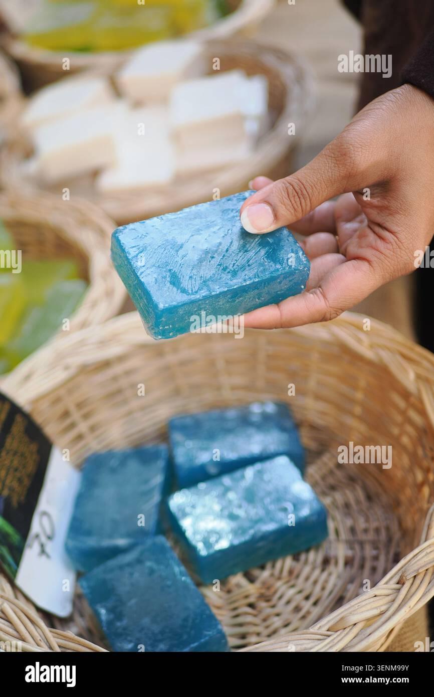 Hand holds blue soap bar in market basket Stock Photo - Alamy